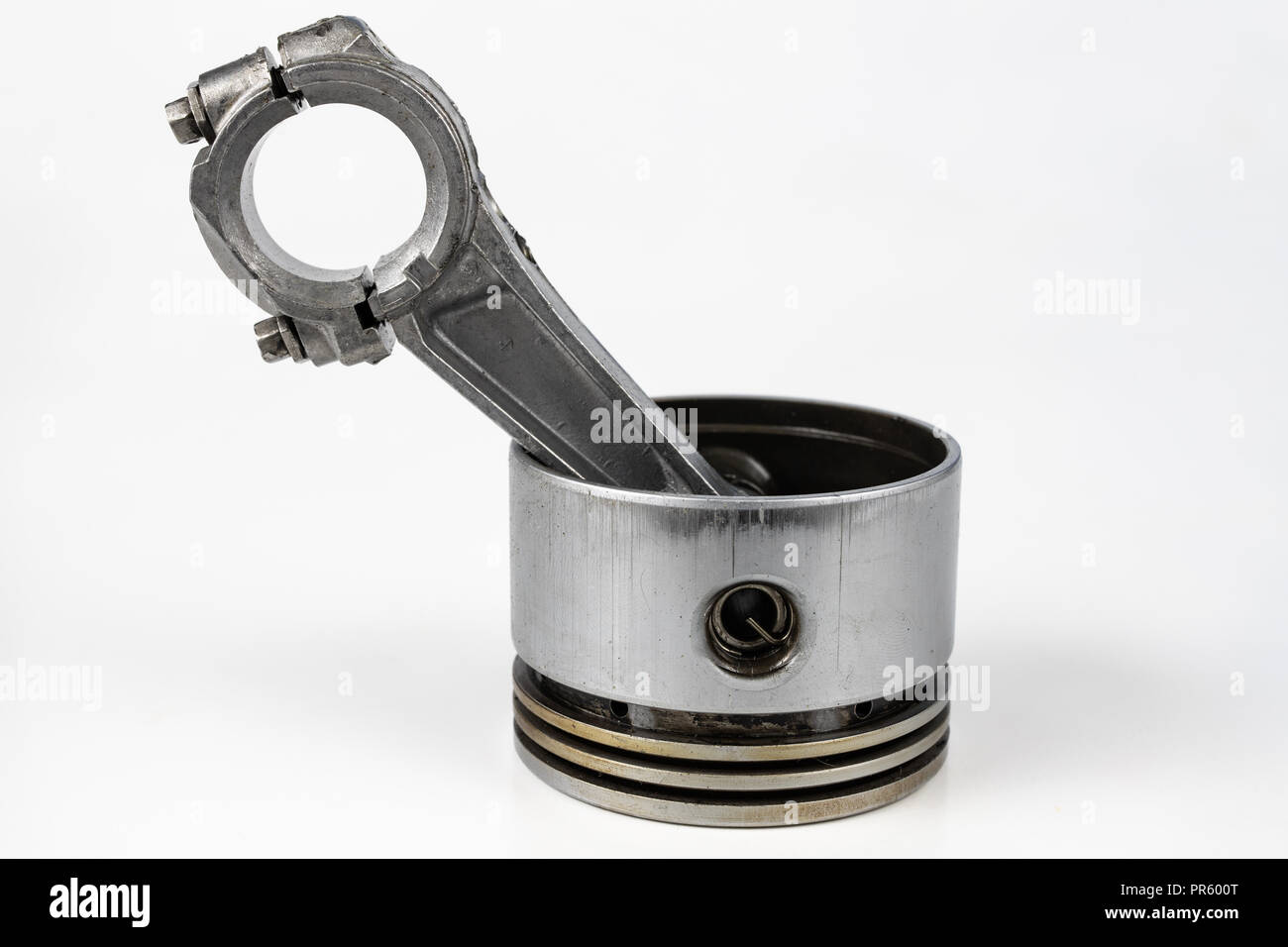 A small combustion engine piston on a white table. Spare parts for ...