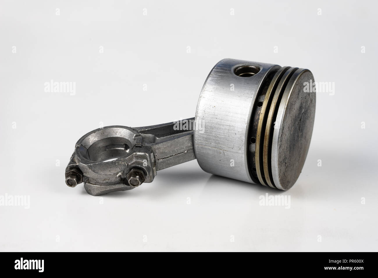 A small combustion engine piston on a white table. Spare parts for ...