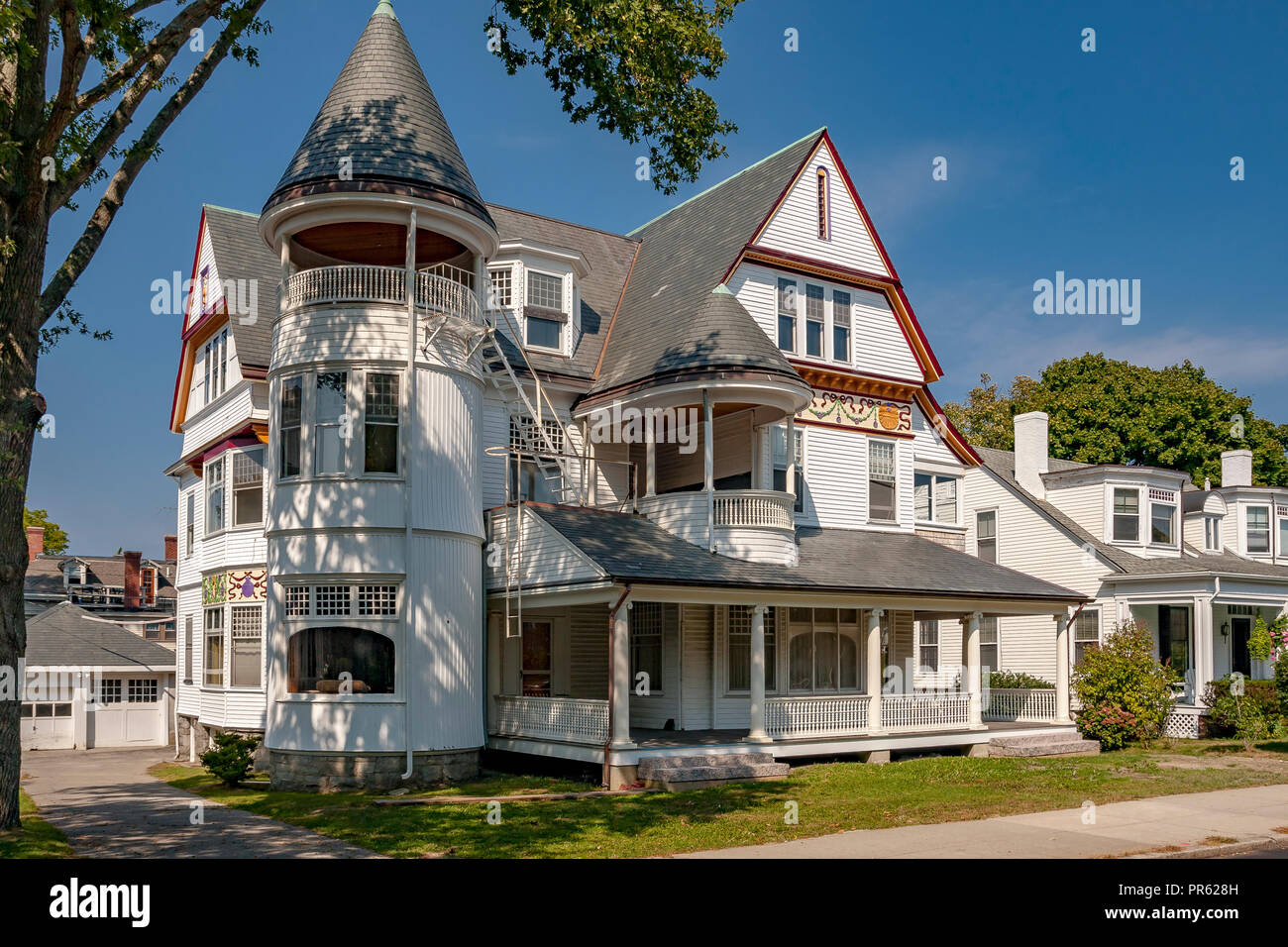 White Wooden house with turret and grey slate roof and front porch, Kay ...