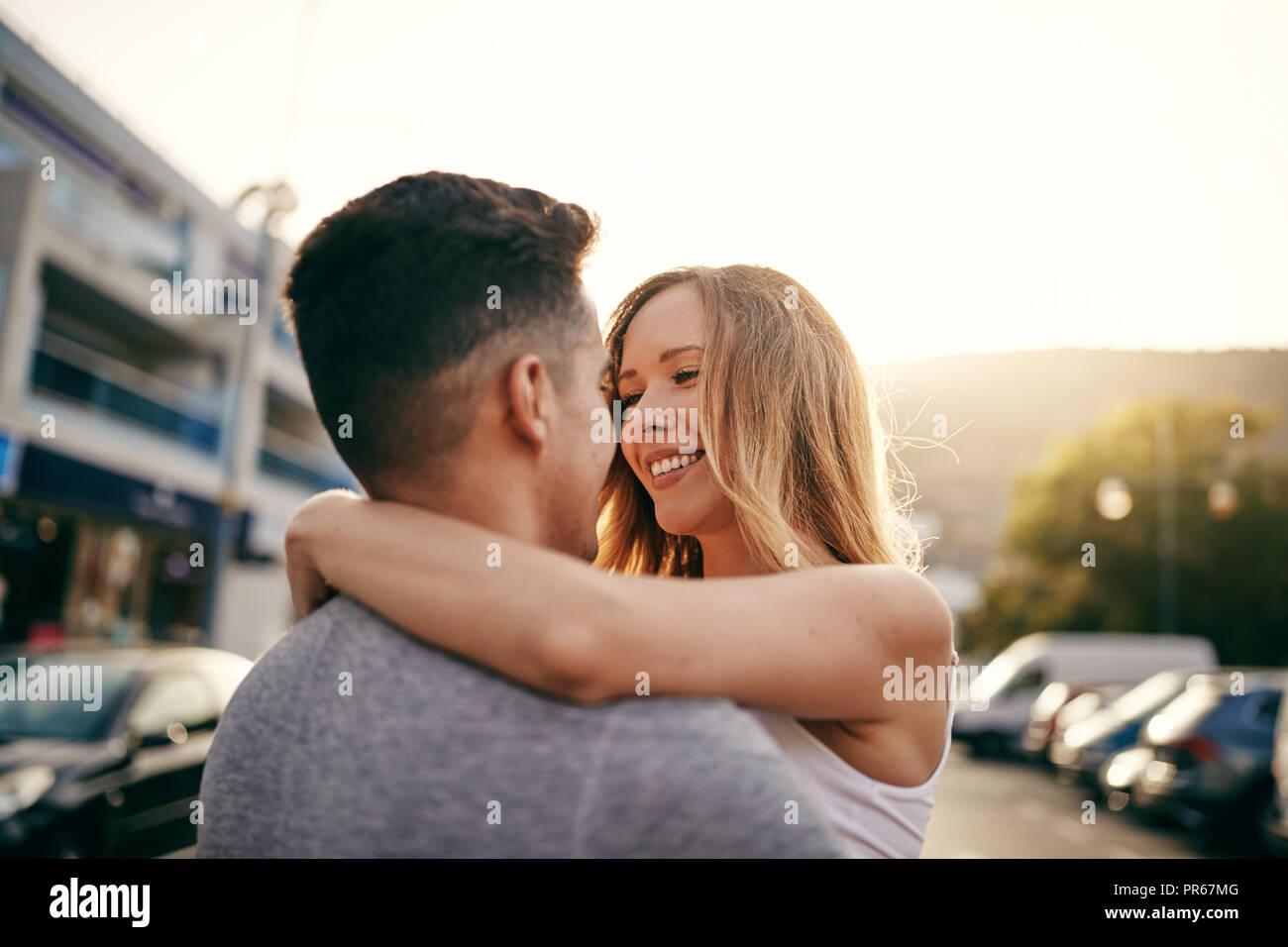 Affectionate young couple looking into each other's eyes while standing ...