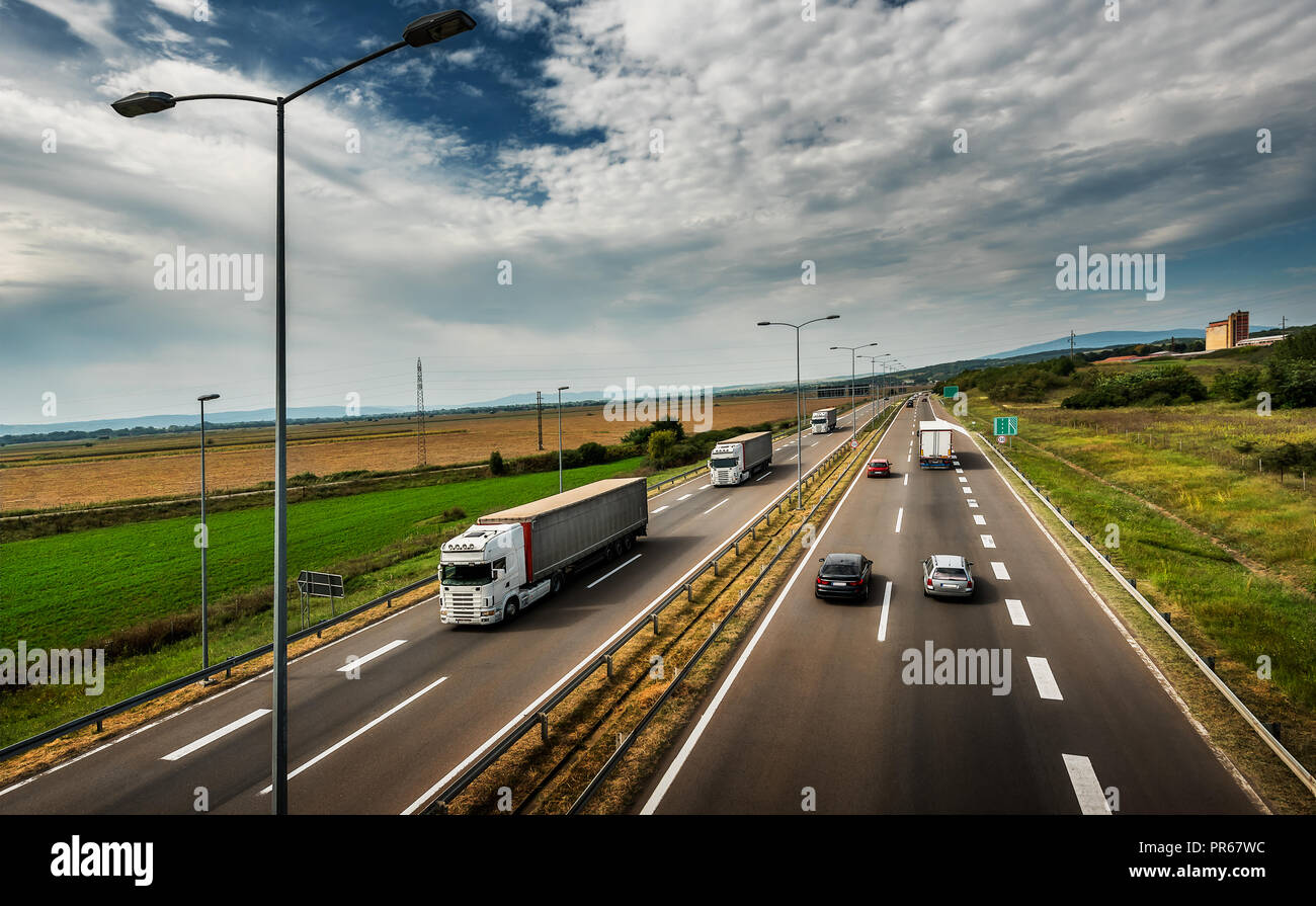 White Lorries passing - Highway Traffic through colorful Landscape ...