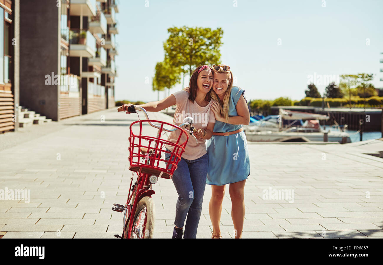 Young best friends laughing and having fun together while walking with ...