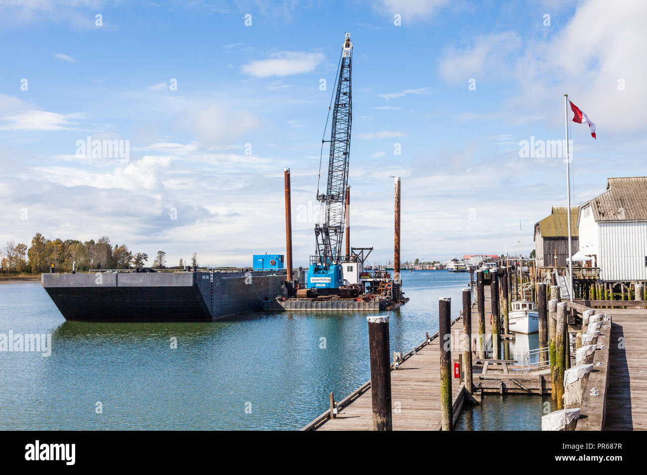 Floating dredging platform with a debris barge alongside in the ...