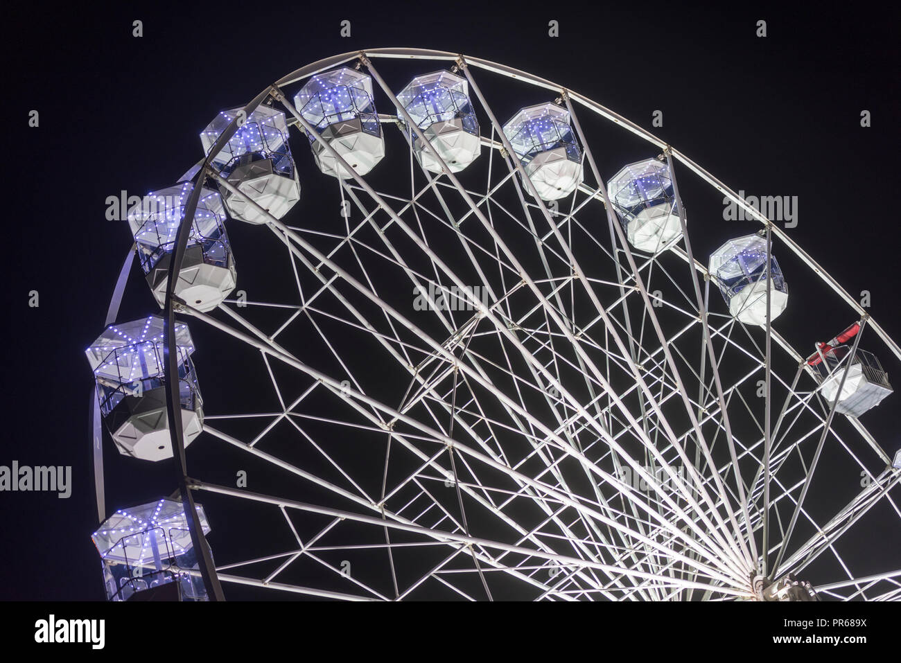 a large fairground ferris or big wheel ride illuminated and lit with ...