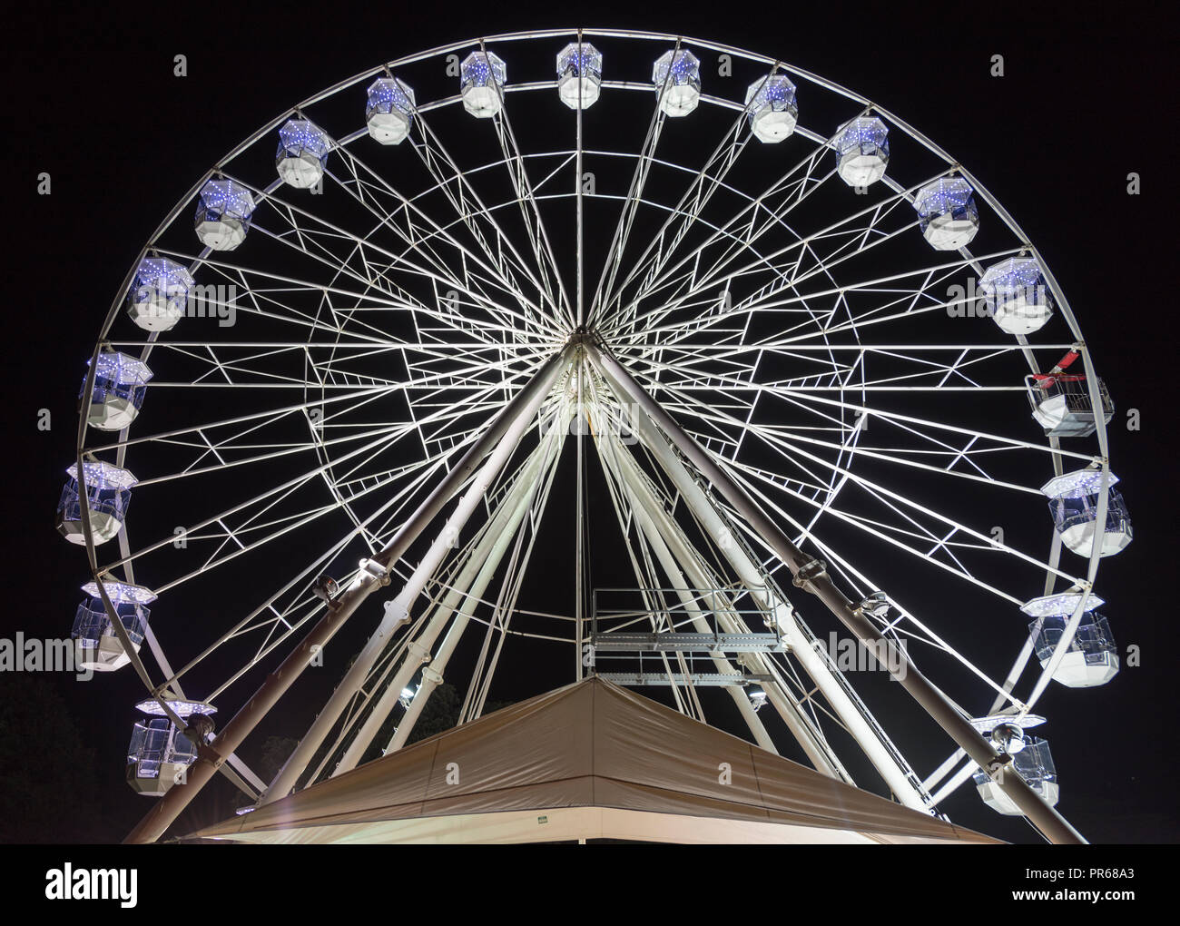 a large fairground ferris or big wheel ride illuminated and lit with ...