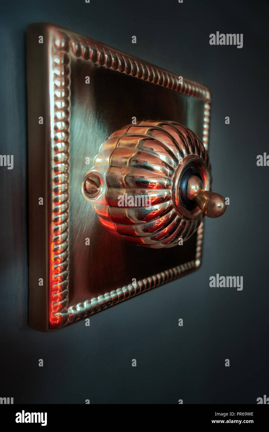 Brass Lightswitch fitting on a house wall Stock Photo - Alamy