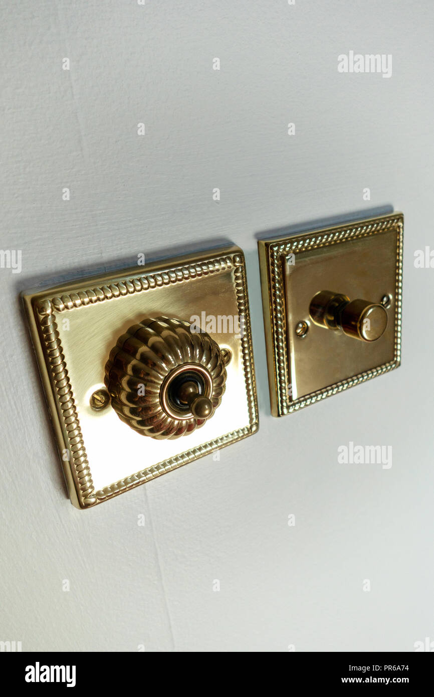 Brass Lightswitch fitting on a house wall Stock Photo - Alamy