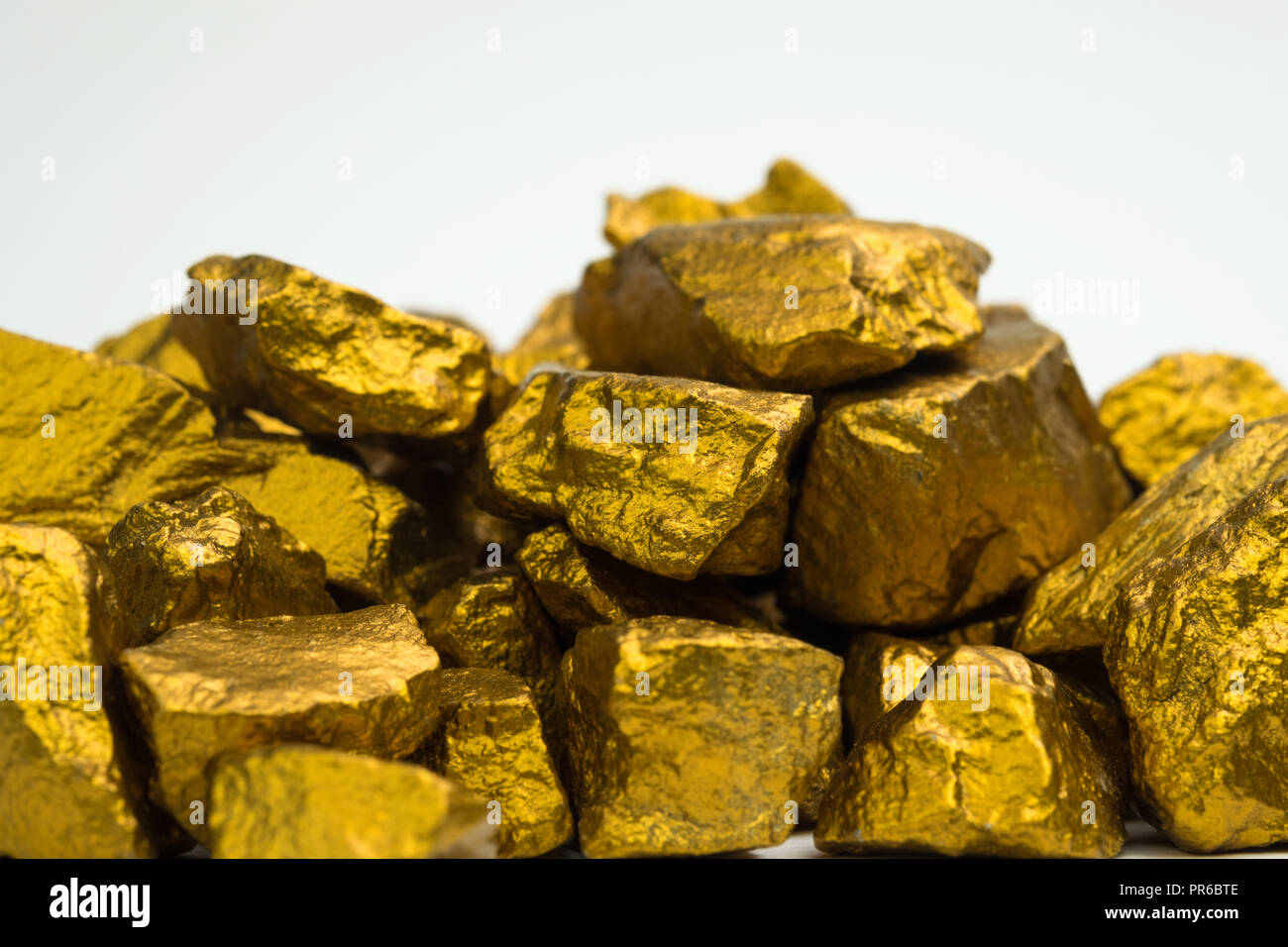 A pile of gold nuggets or gold ore isolated on white background ...