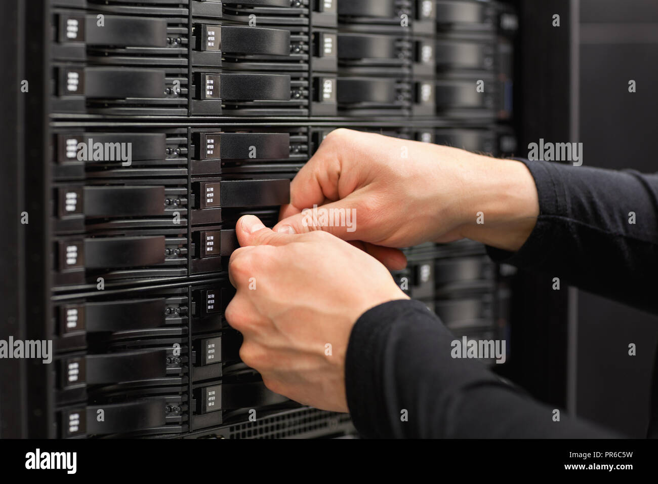 Male IT Engineer Adjusting Hard Drives In SAN At Datacenter Stock Photo ...