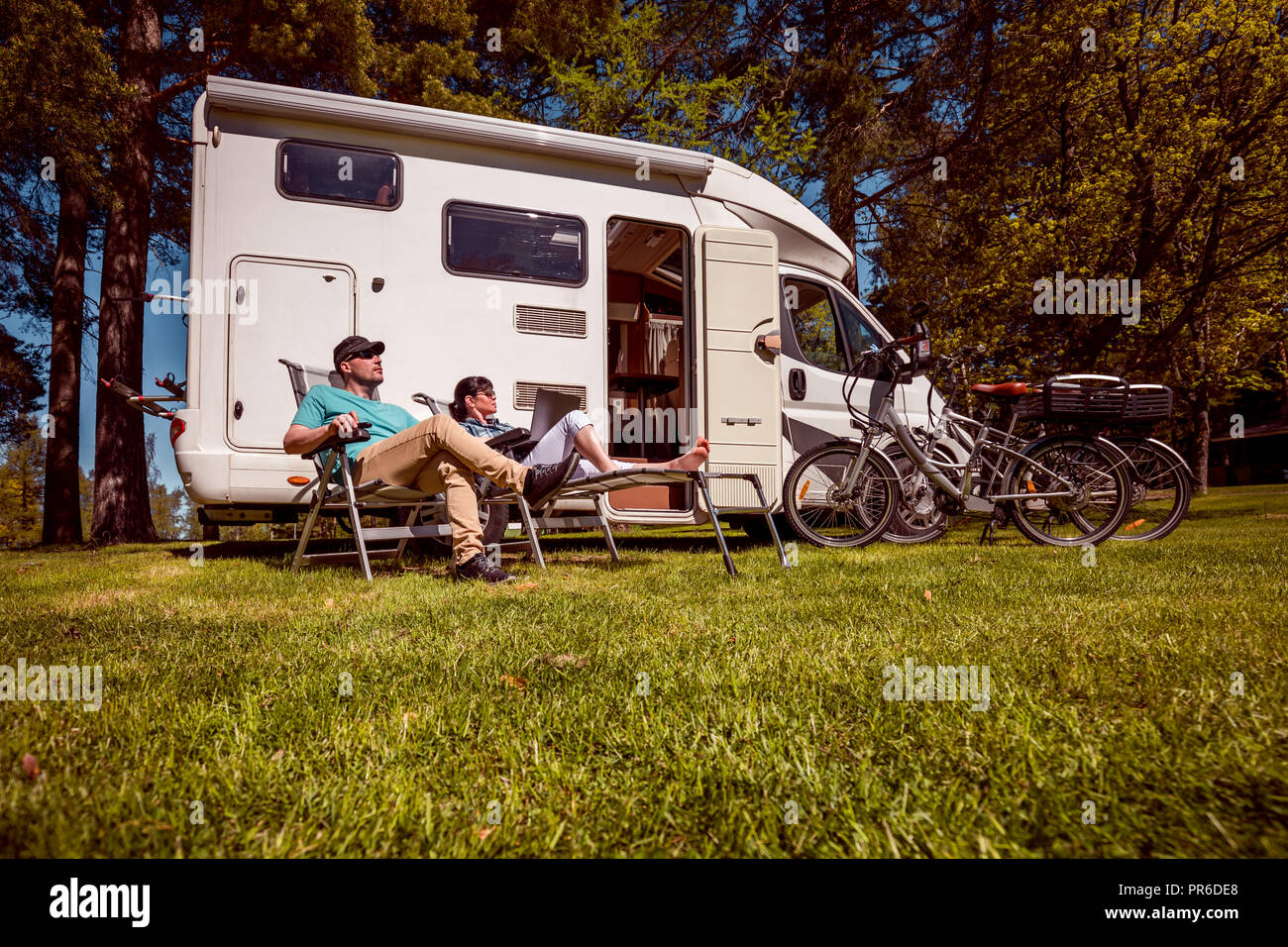 Woman with a man resting near motorhomes in nature. Family vacation ...