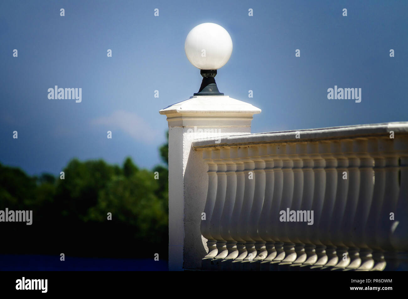 A white baluster with a lamp in front of the forest on the lake Stock ...