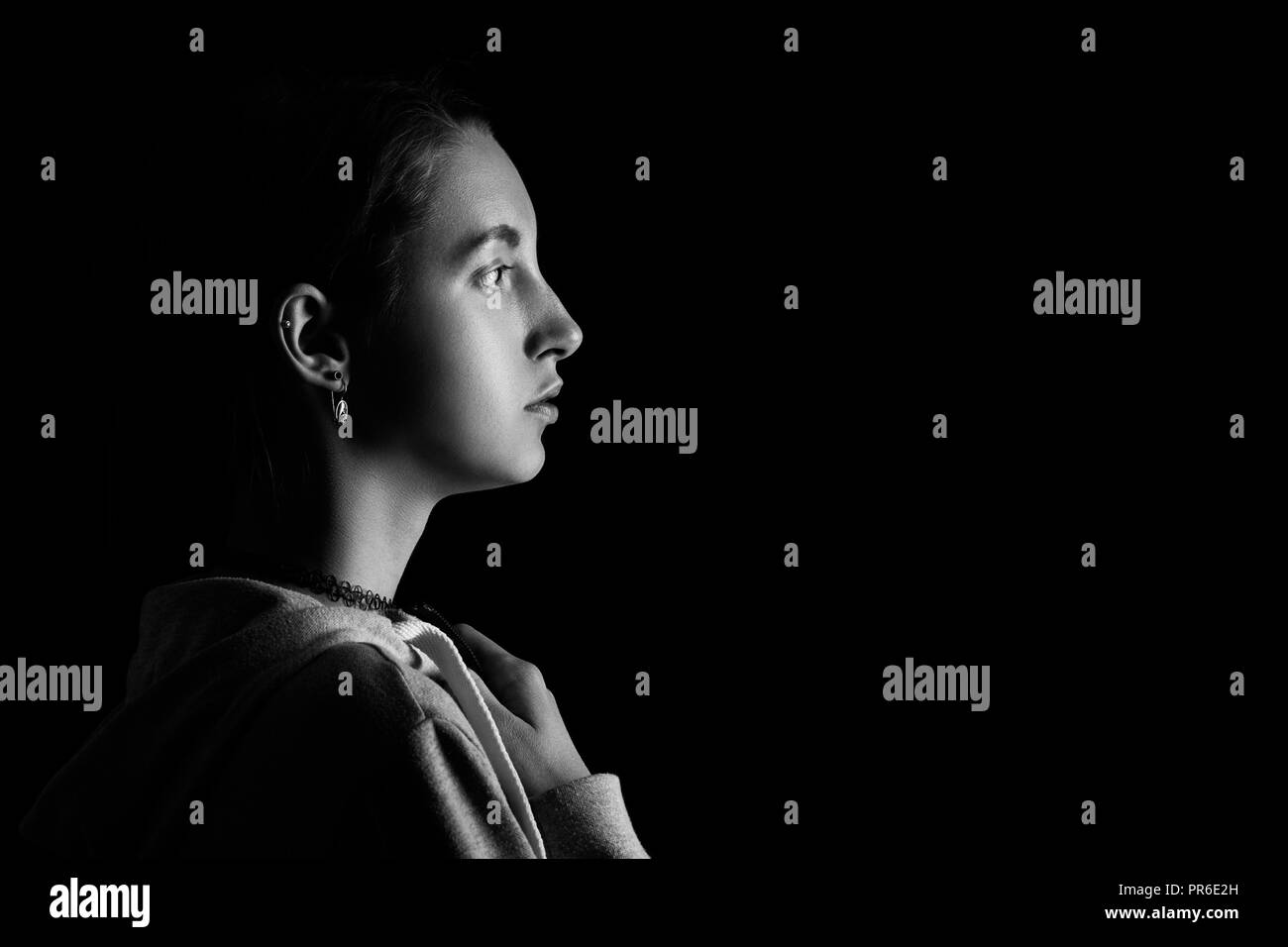 sad young female profile on black background with copy space ...