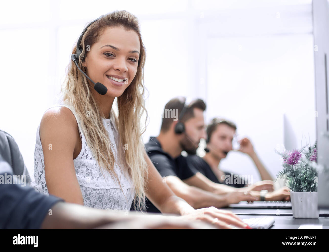 smiling call center employee sitting at his Desk Stock Photo - Alamy