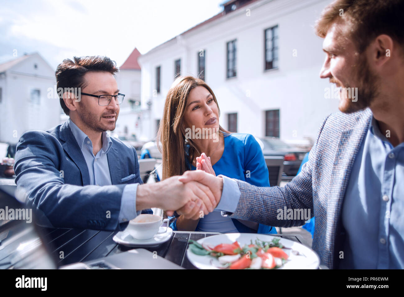 colleagues greeting each other with a handshake in the cafe Stock Photo ...