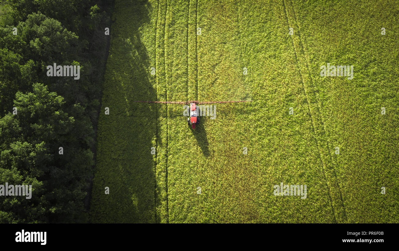 Agricultural machinery in the field. Tractor with a sprayer. Aerial ...