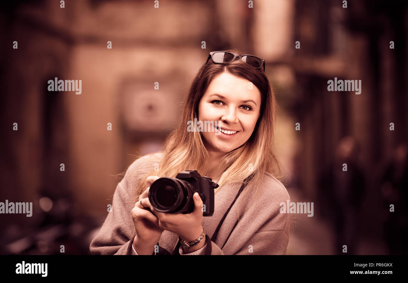 Cheerfu smiling young girl holding camera in hands and photographing in ...
