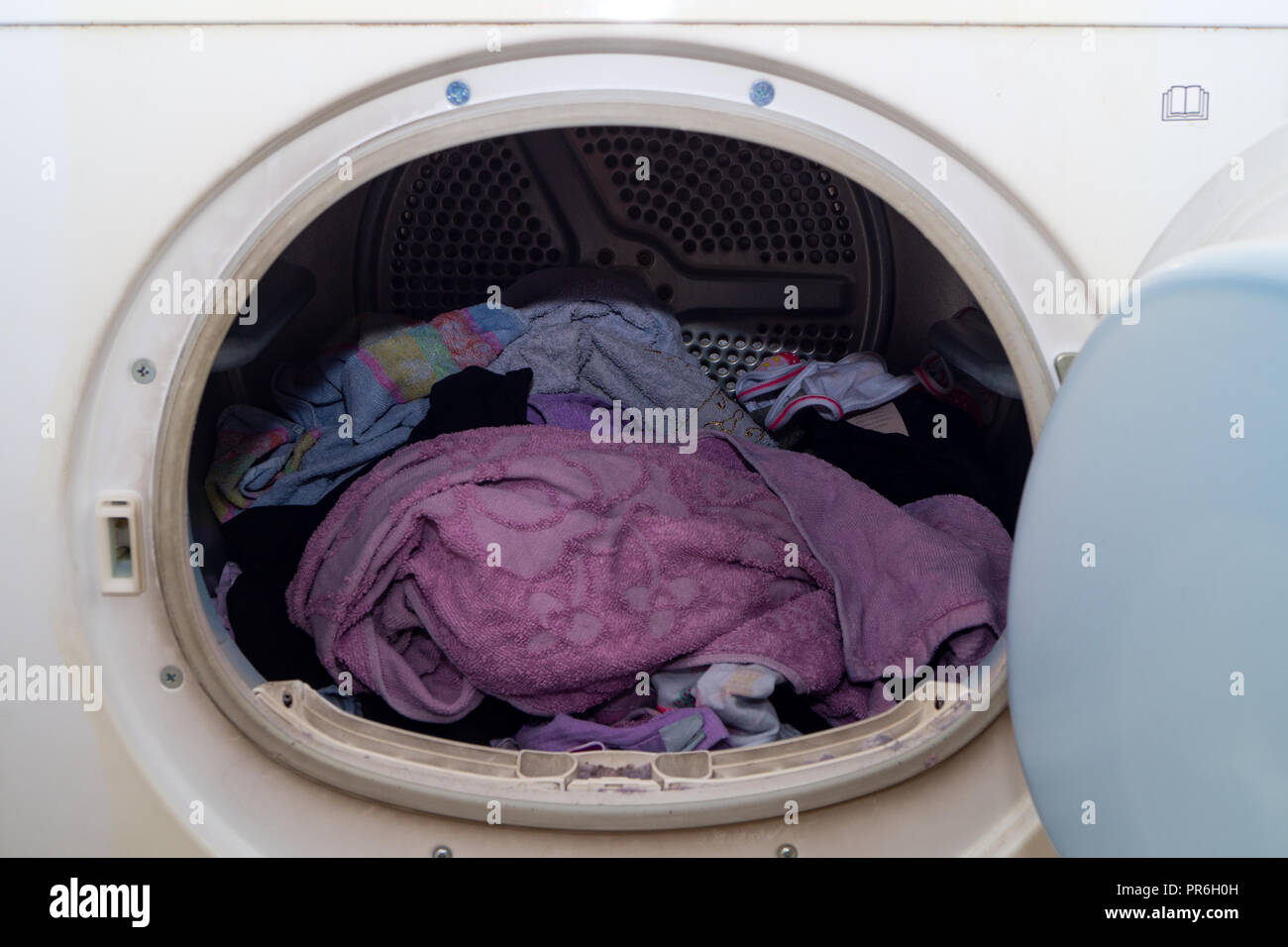 Washing machine porthole in the foreground with laundry inside Stock ...