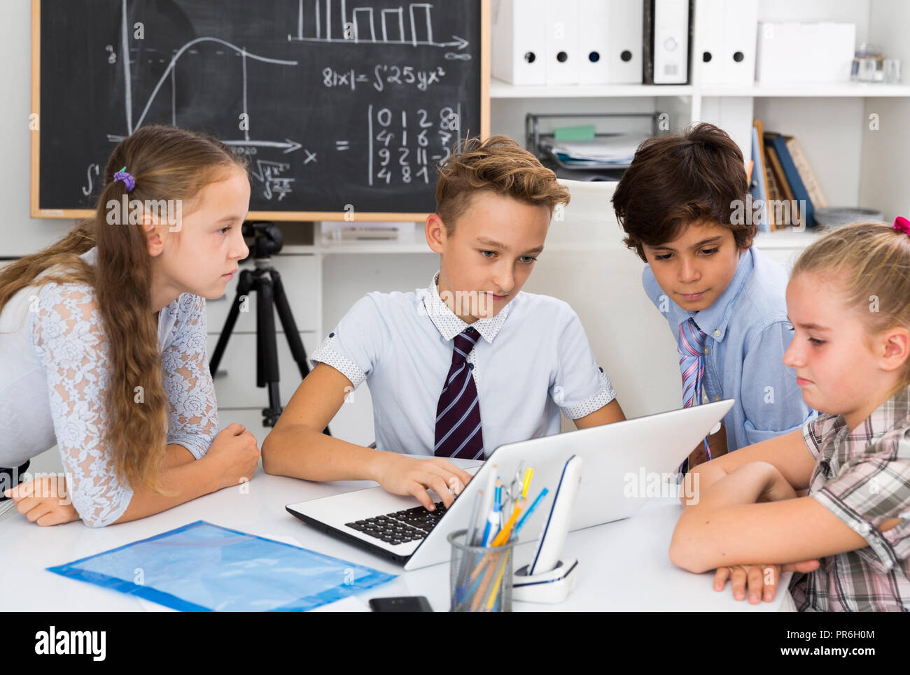 Group of children near laptop talking about mathematics indoors Stock ...