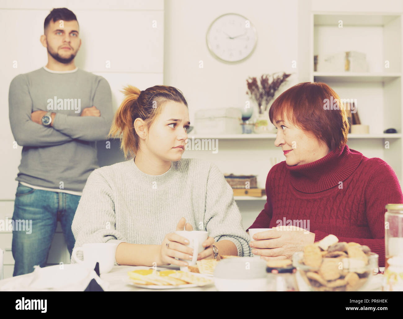 Senior woman calming chagrined girl during her quarrel with boyfriend ...