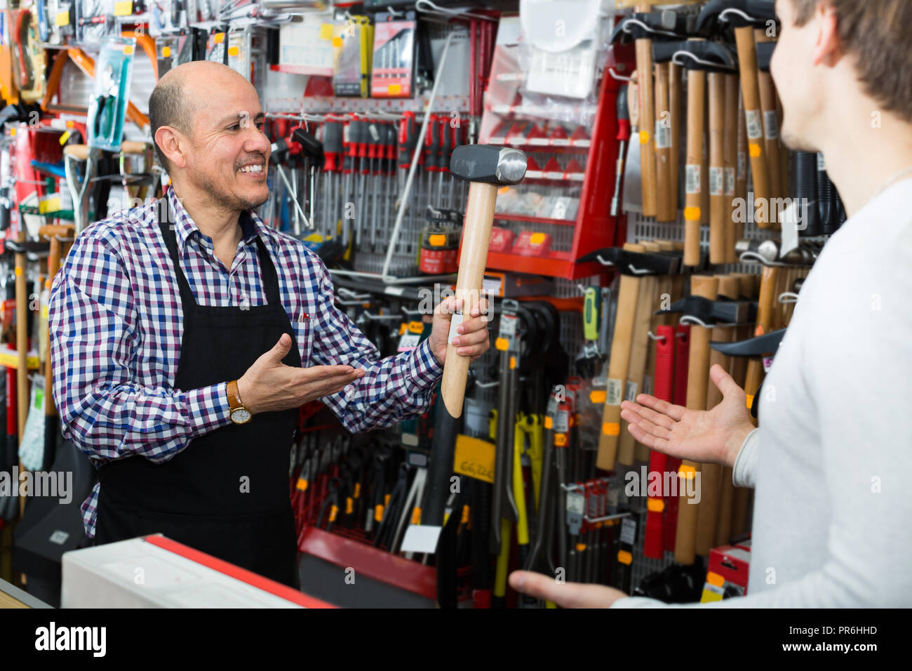 caucasian salesman showing different tools and instruments in ...
