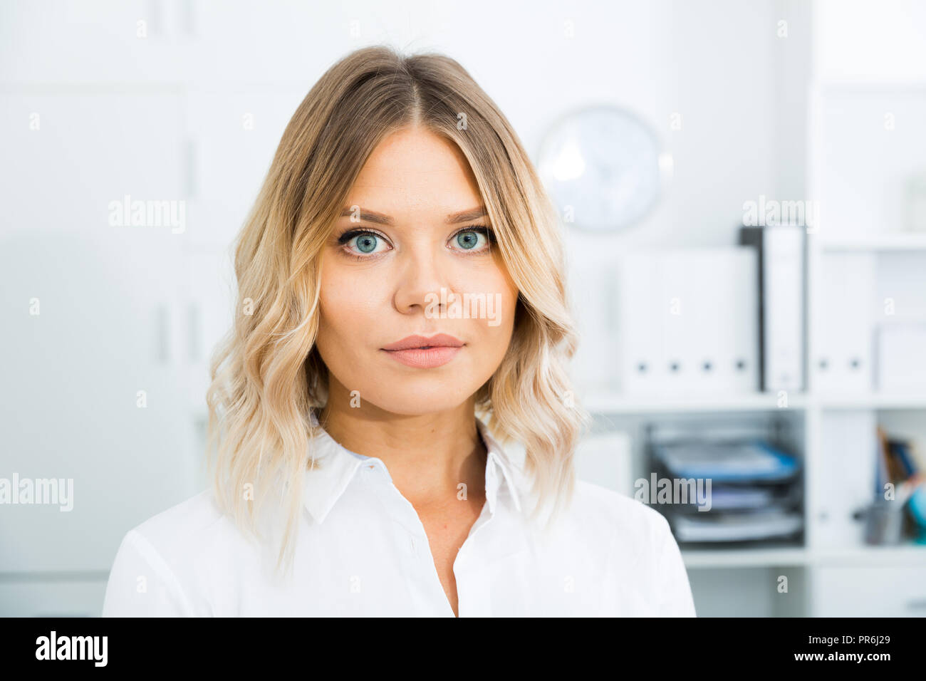 Kindness girl in white shirt in modern office close-up Stock Photo - Alamy