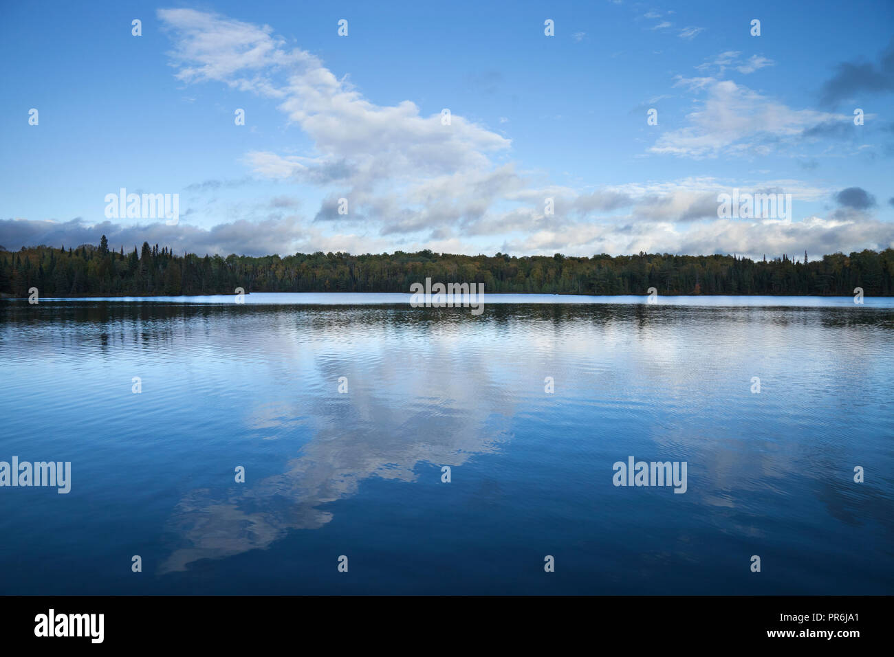 Blue sky and clouds over calm lake at dusk in northern Minnesota Stock ...