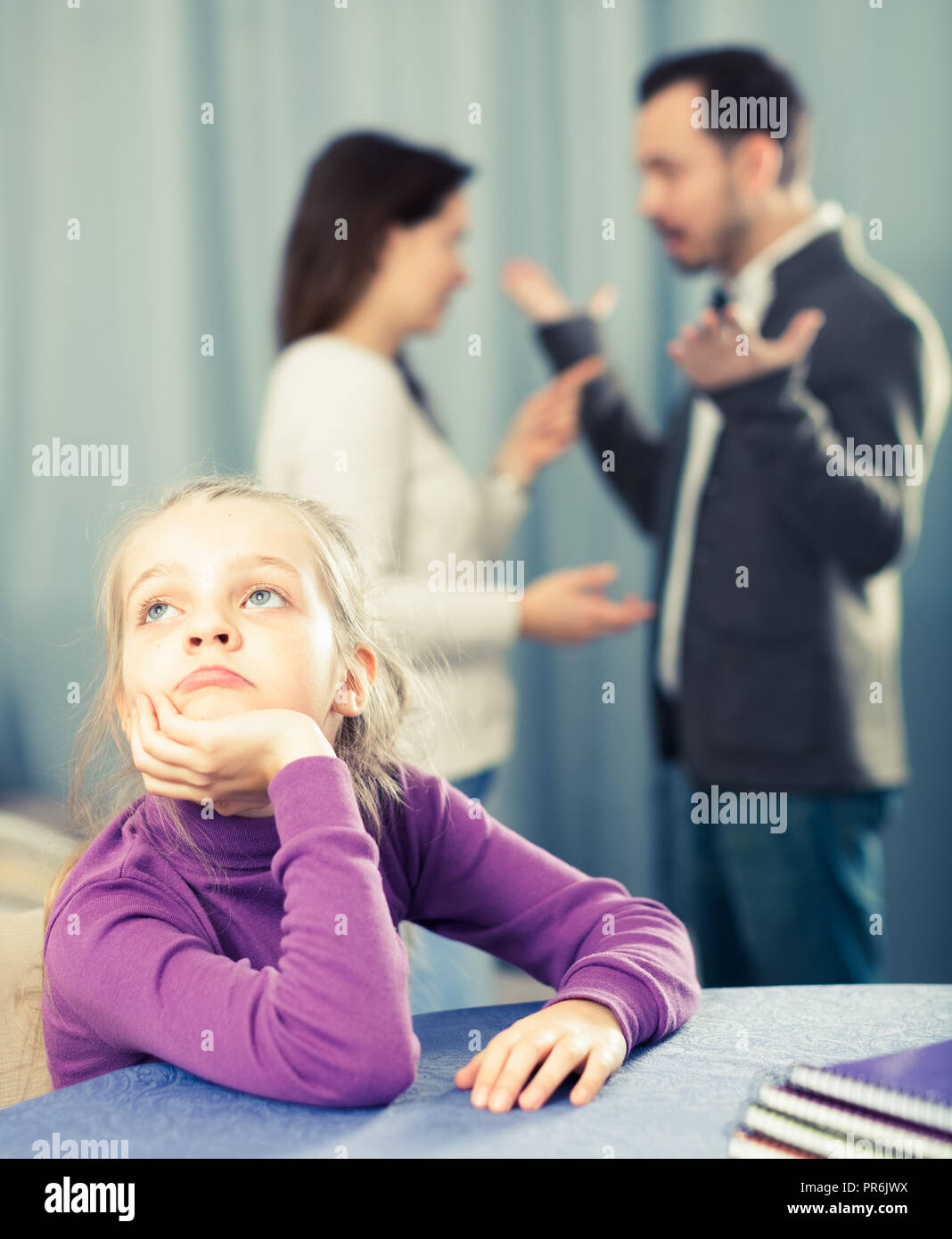 Young parents arguing with each other while their daughter at home ...