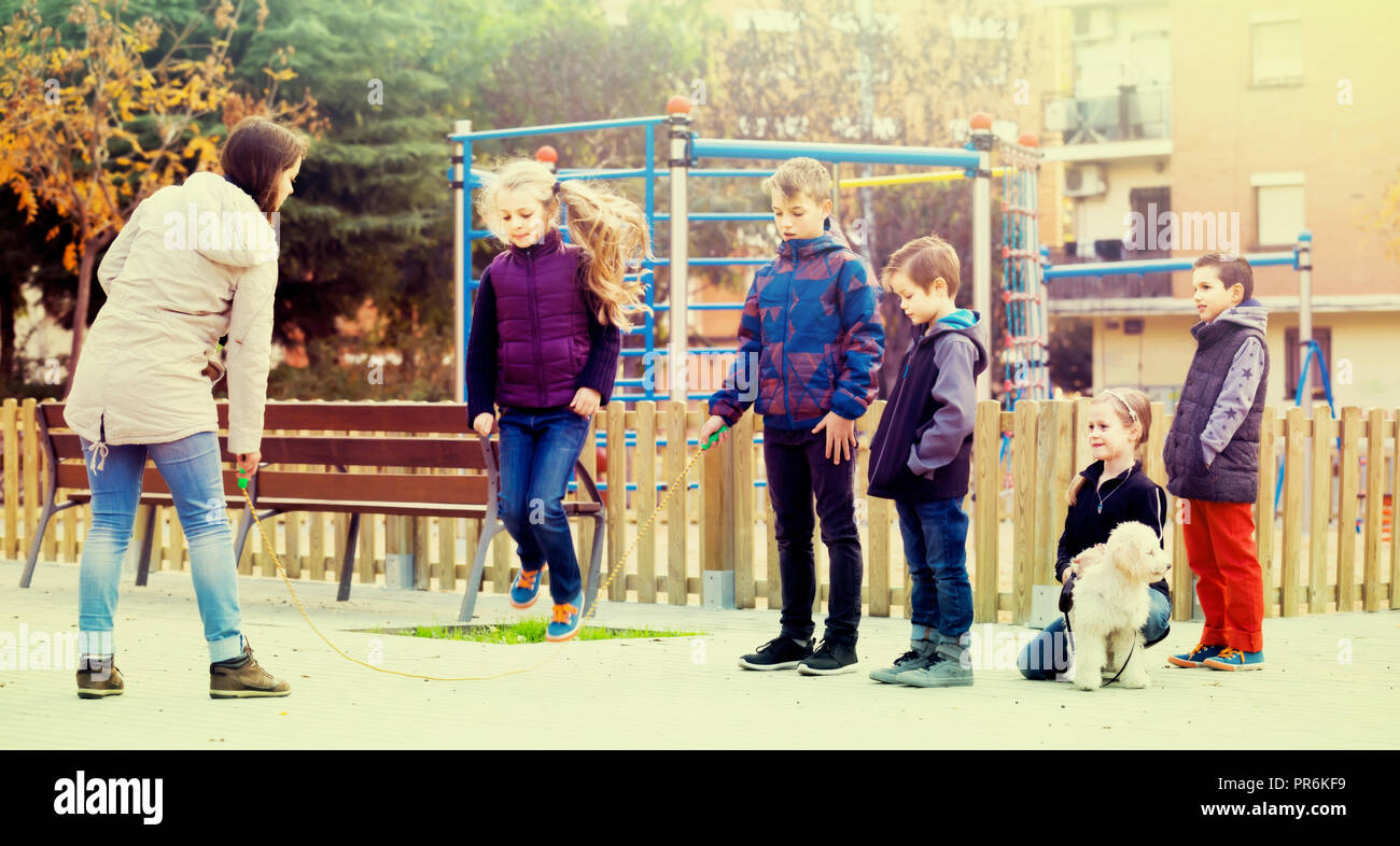 happy spanish children playing rubber band jumping game and laughing ...