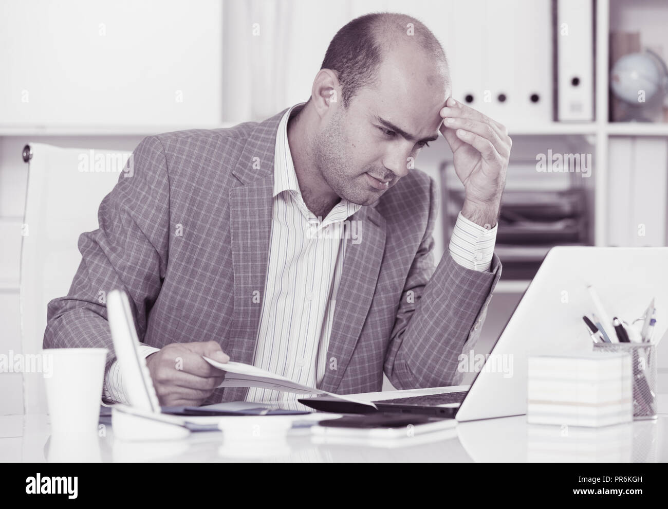 Portrait of businessman in stress sitting at the table with water Stock ...