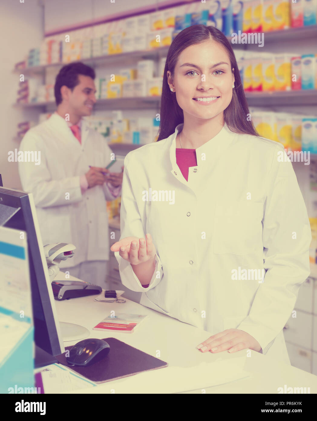 Professional young russian pharmaceutists at reception of drugstore ...