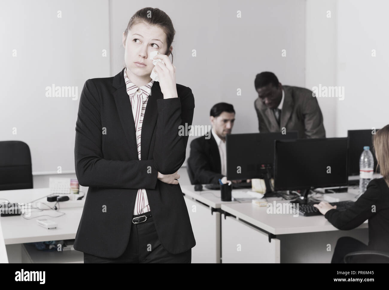 Unhappy and crying girl standing at modern open plan office on ...