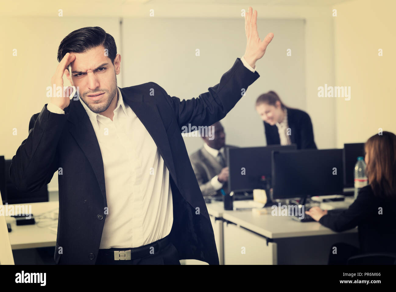 Angry manager standing in office dissatisfied with teamwork of ...