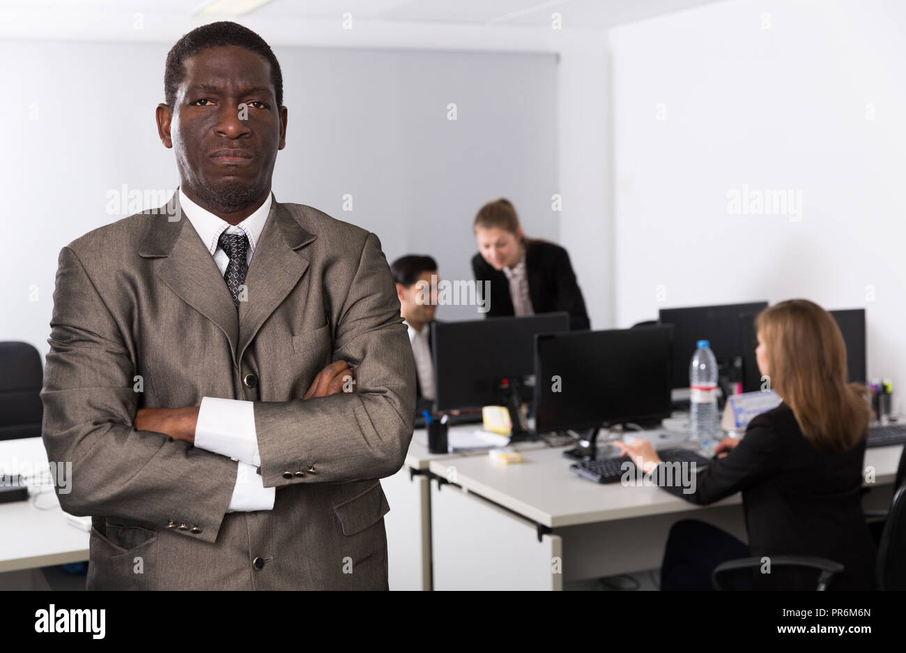 Confident African American businessman standing with arms crossed in ...