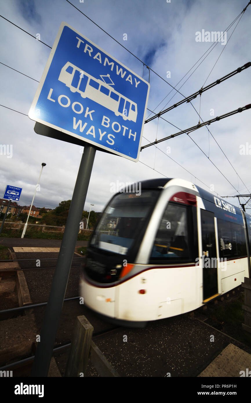 An Edinburgh tram passes by a caution sign as it makes its way over a ...