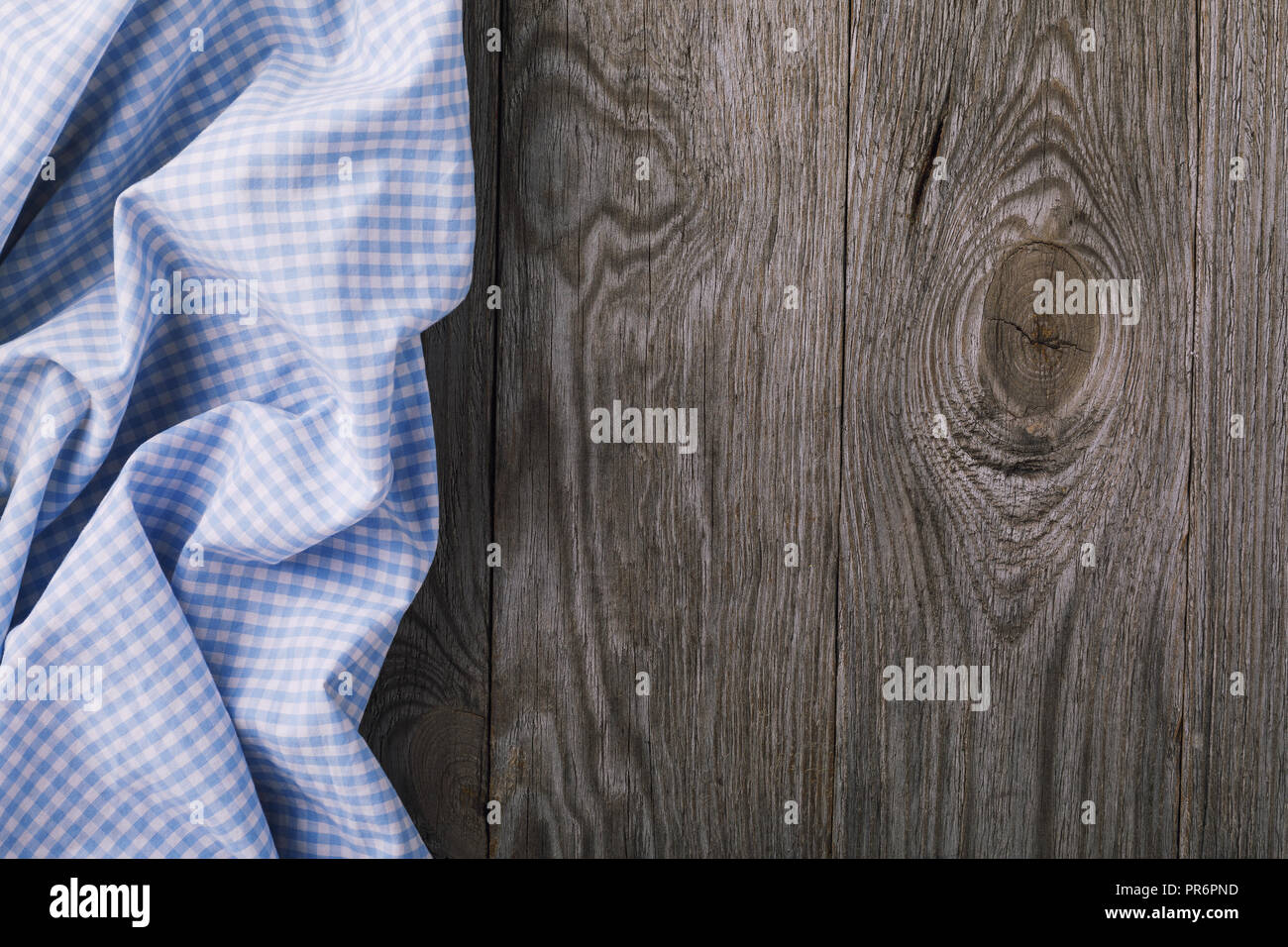 Top view of blue tablecloth located on left side of wooden table. Food ...