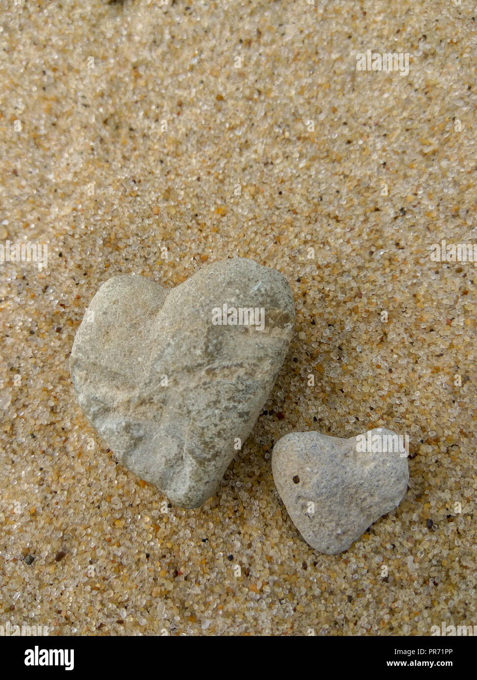 2 Stone hearts in sand Stock Photo - Alamy