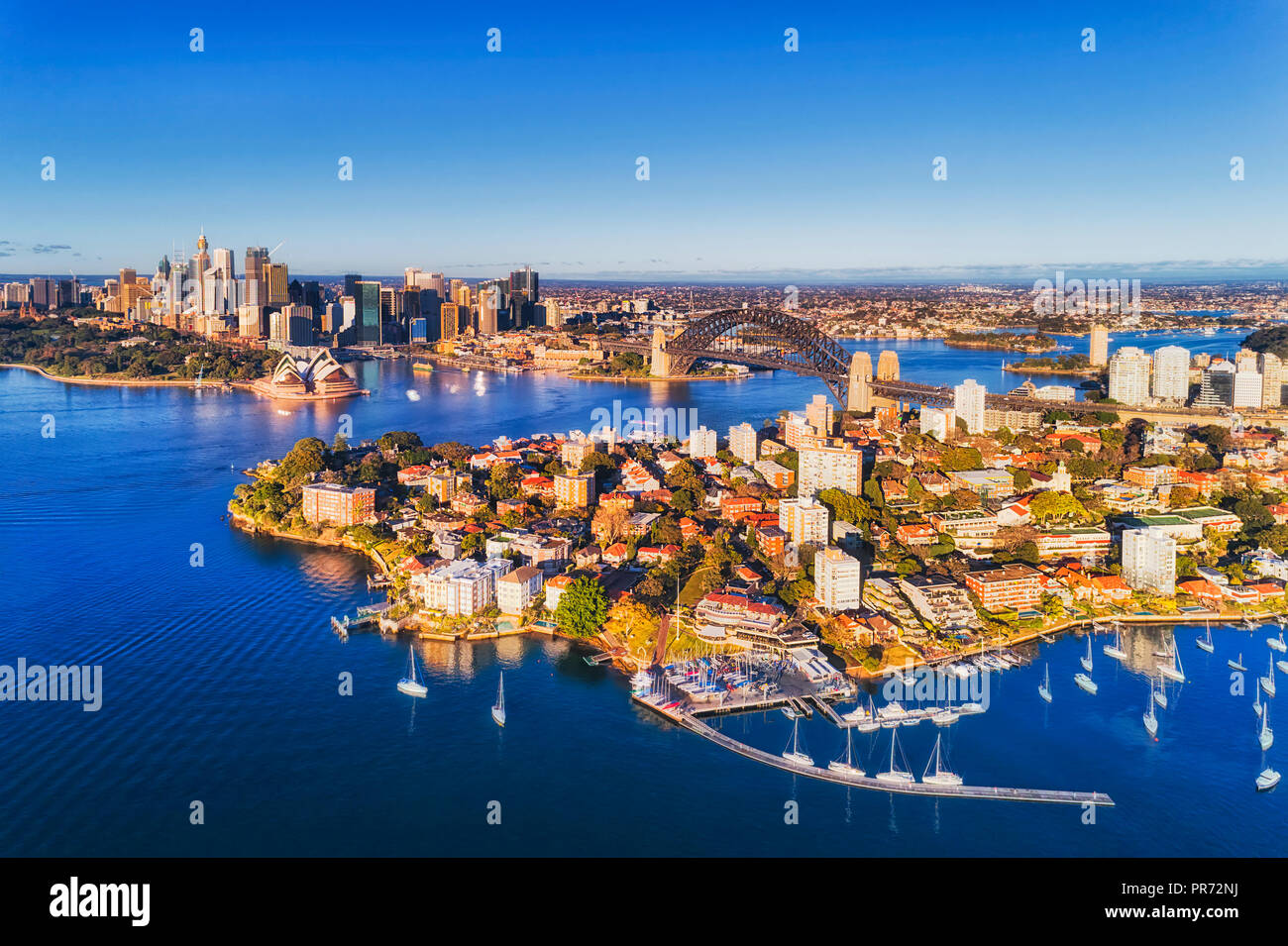 Rich blue waters of Sydney harbour reflecting clear blue sky around ...