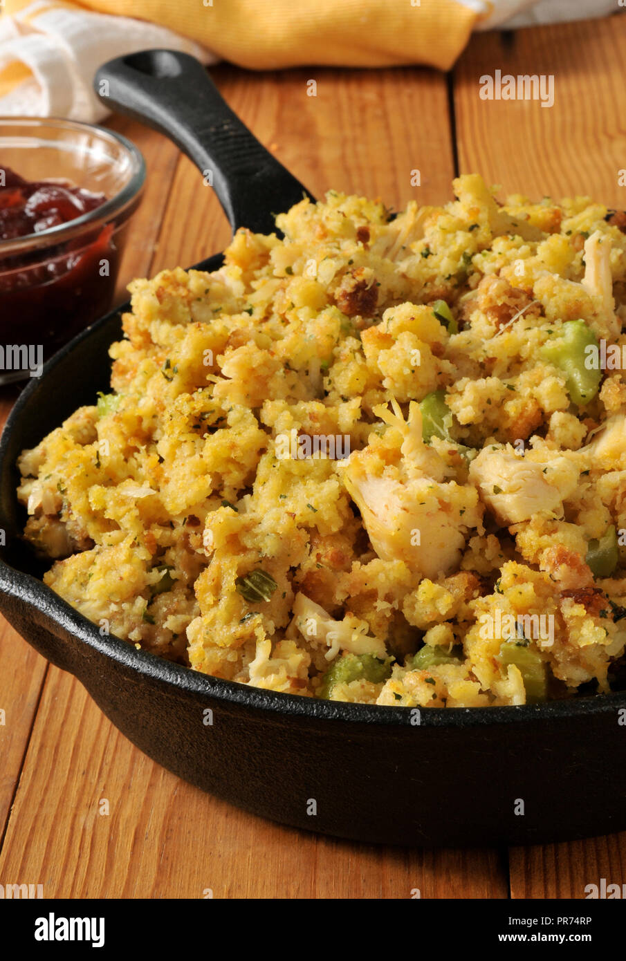 a cast iron skillet with corn bread stuffing with chunks of turkey meat ...