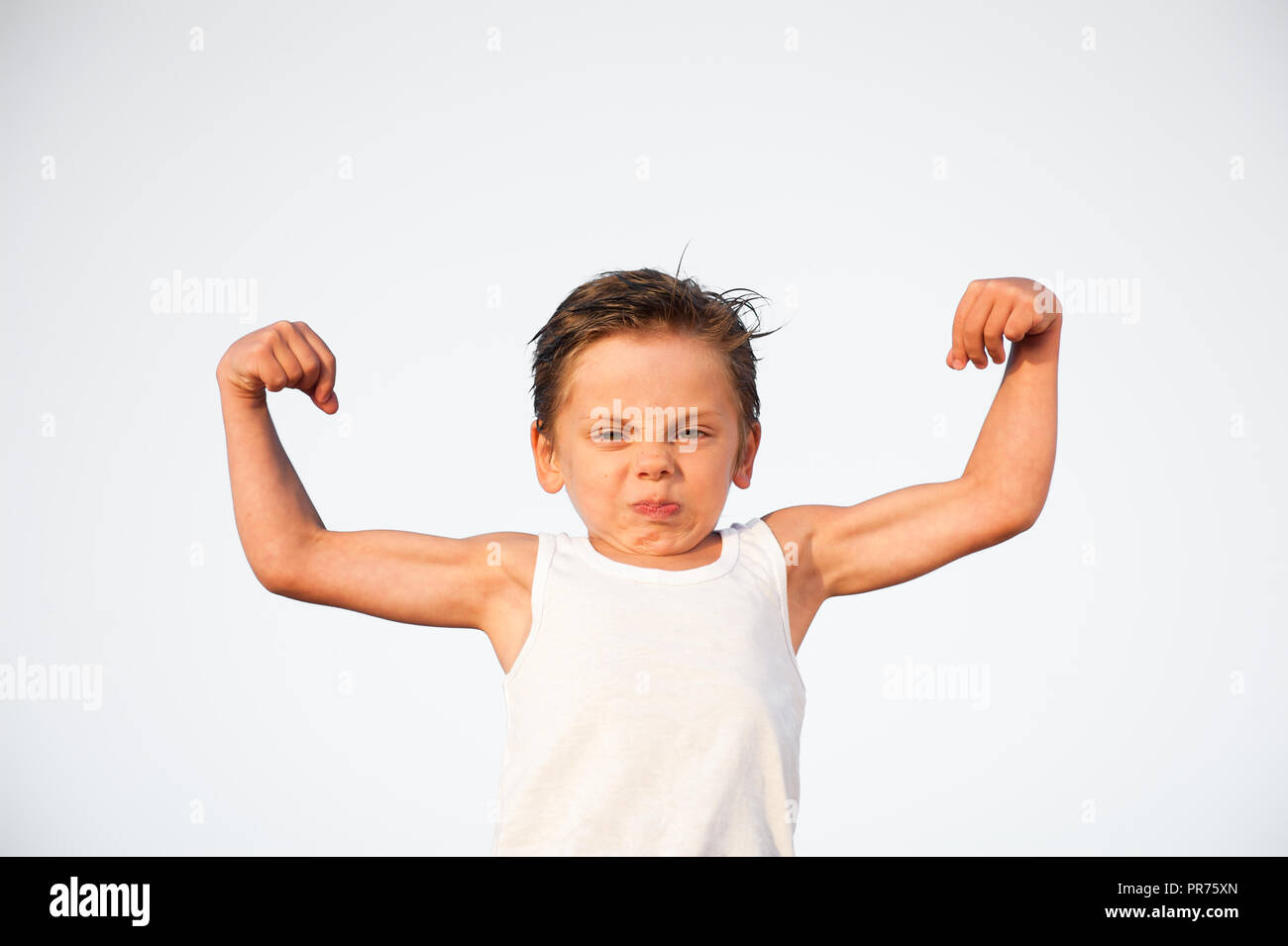 funny little caucasian kid with grimace on his face showing biceps ...