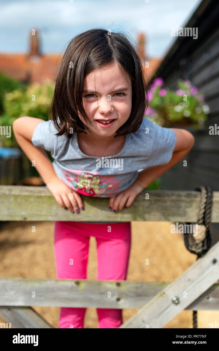 6 year old girl standing on back garden gate hi-res stock photography ...