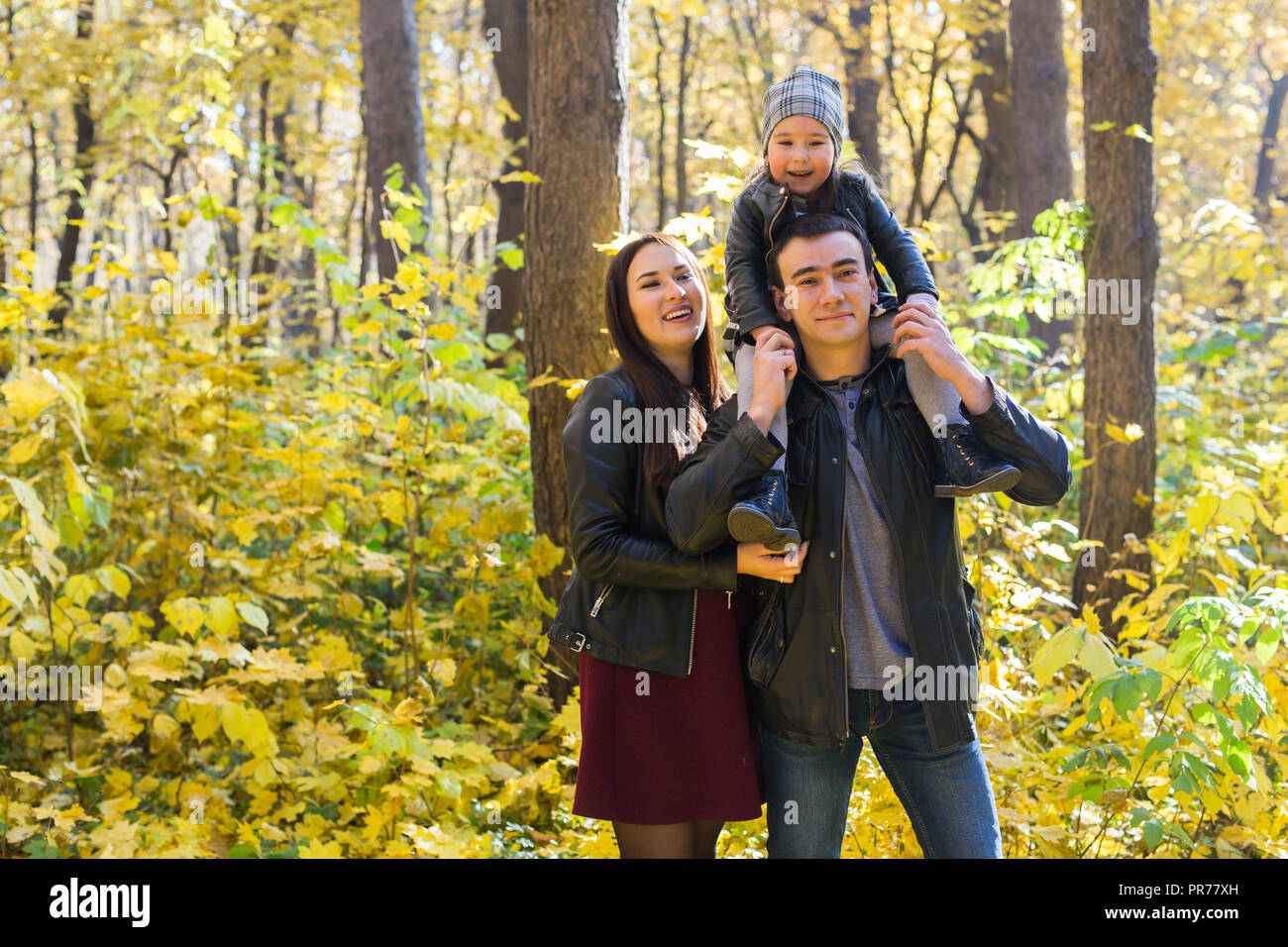 Family, fall, people concept - mixed race young family walking in park ...