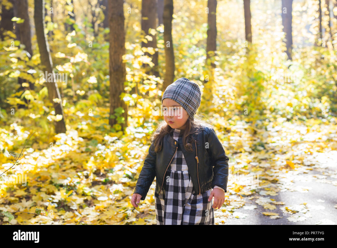 Fall, childhood and season concept - Little girl playing in the autumn ...