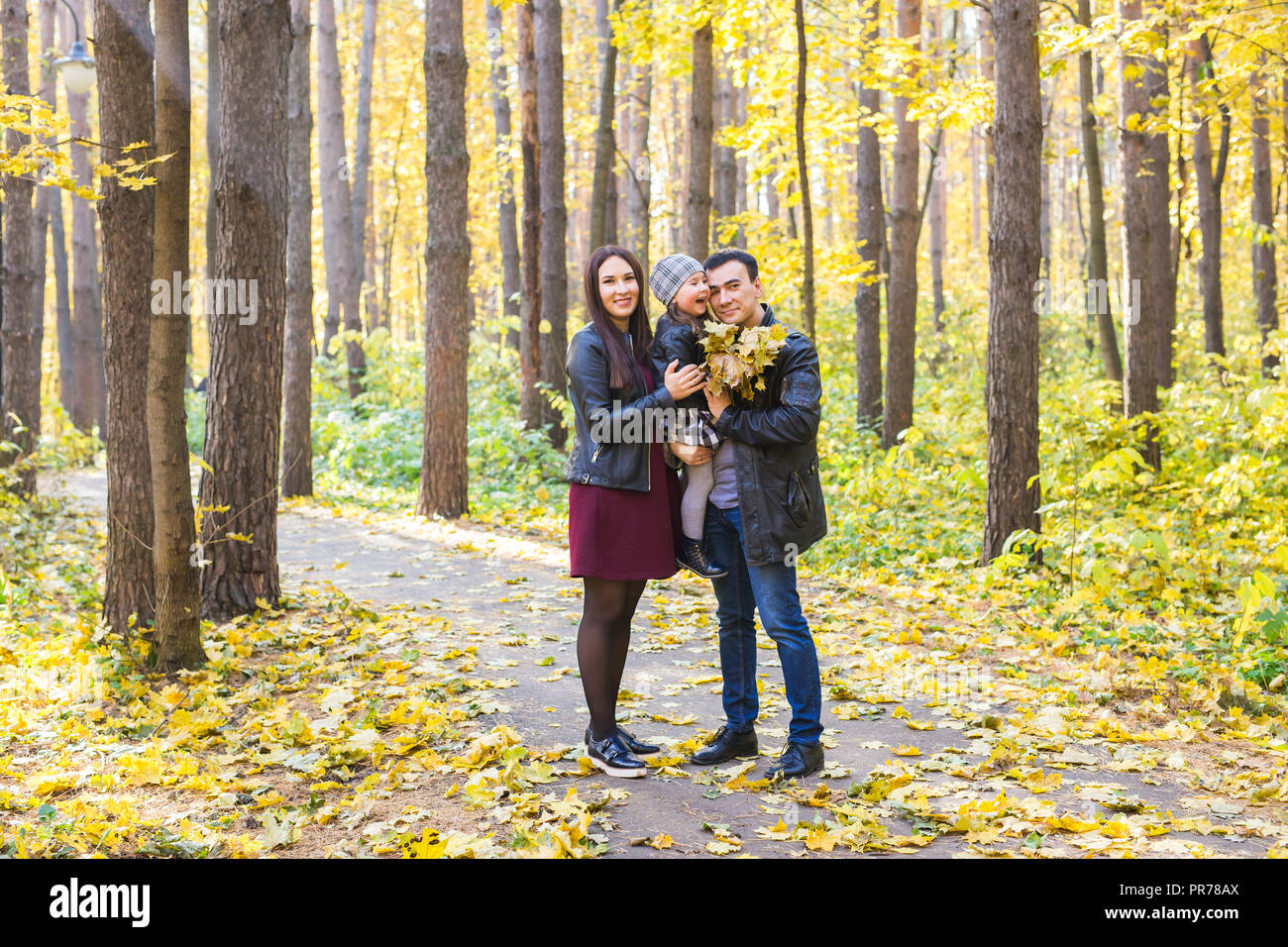Family, fall, people concept - mixed race young family walking in park ...