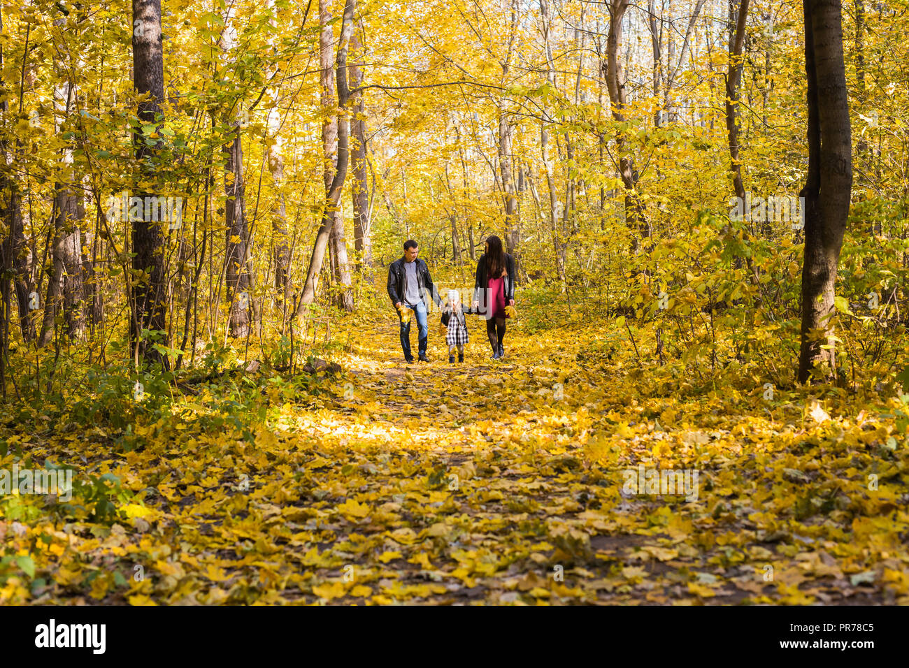 Fall, nature and family concept - happy family walking in autumn park ...
