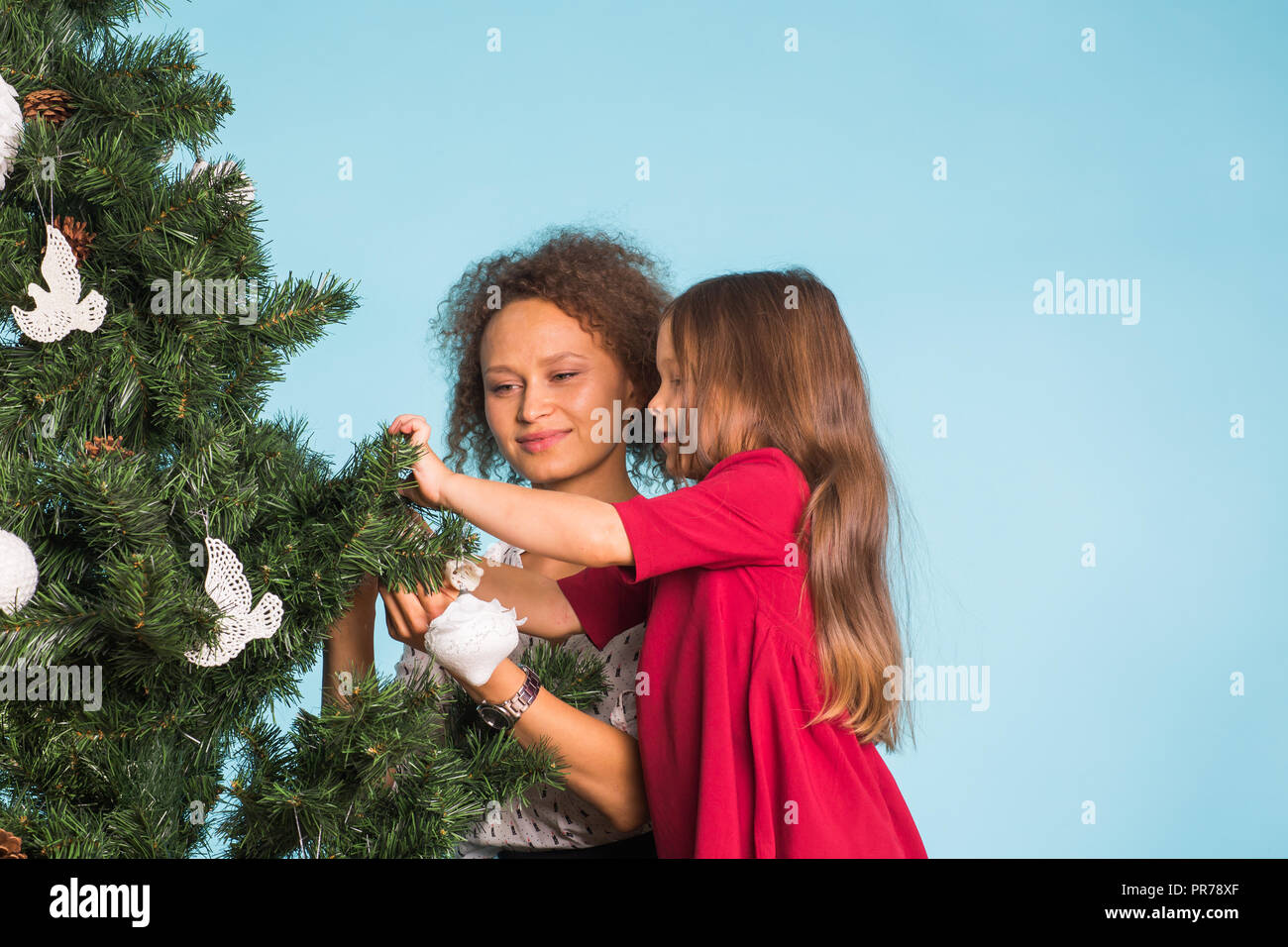 Holidays, family and christmas concept - pretty little girl with mixed ...