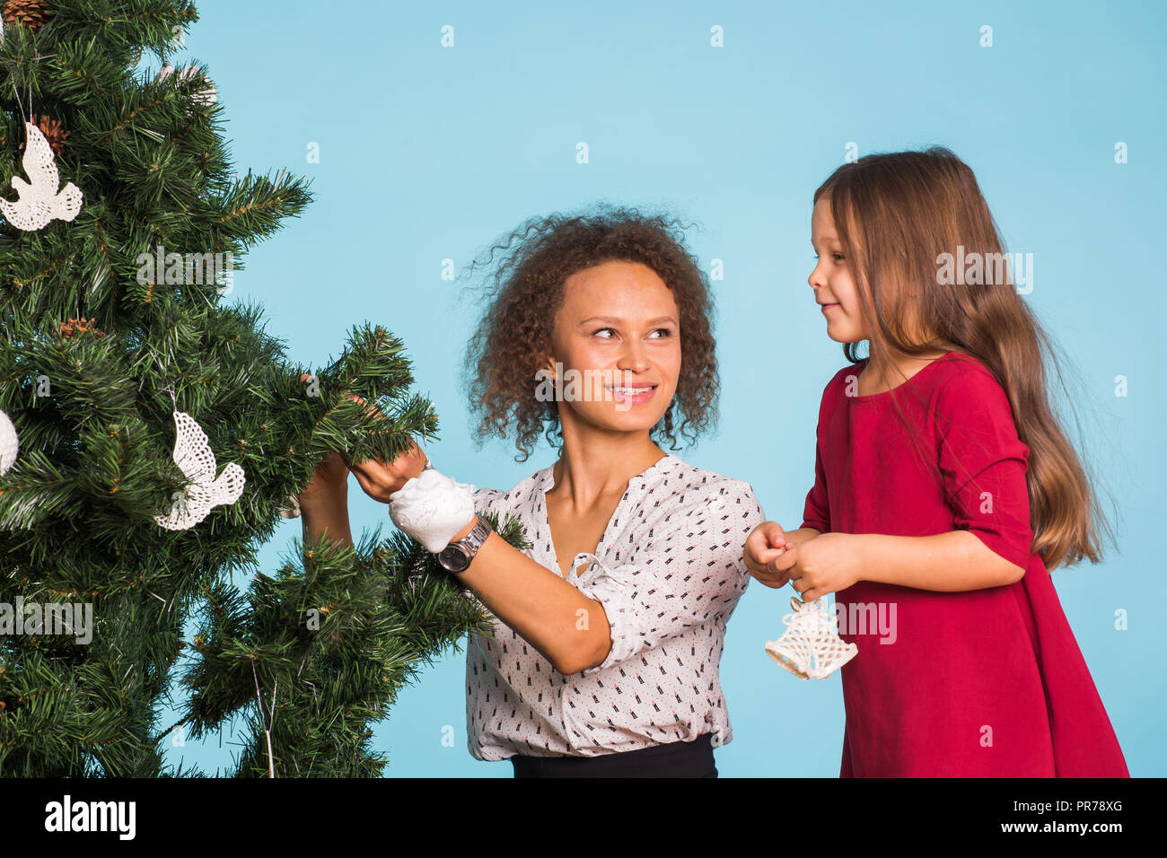 Holidays, family and christmas concept - pretty little girl with mixed ...