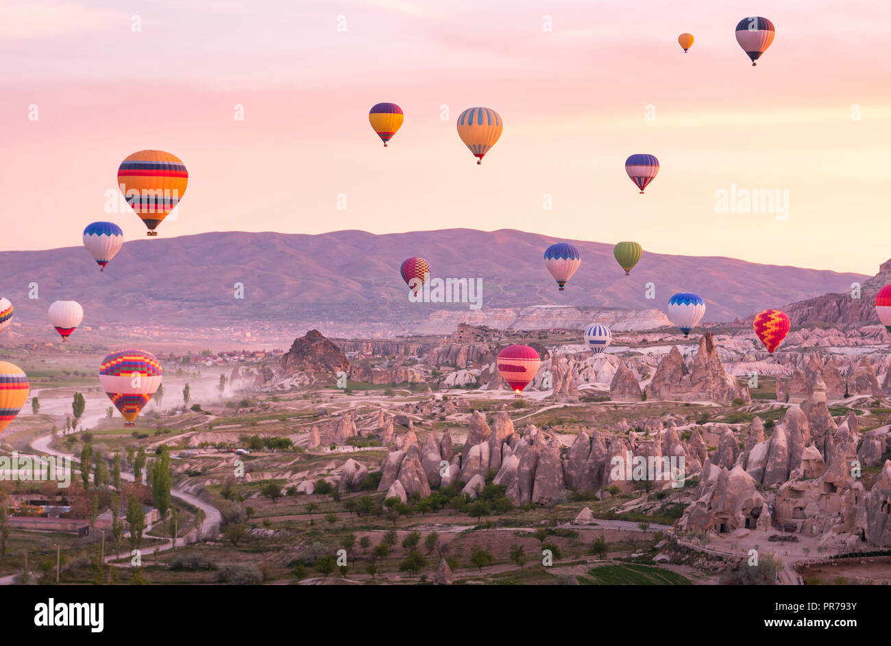 Colorful hot air balloons flying over rock landscape at Cappadocia ...