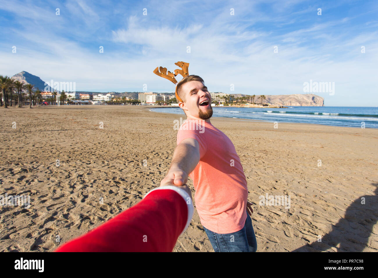 Follow me, holidays and Christmas concept - Happy young man with deer ...