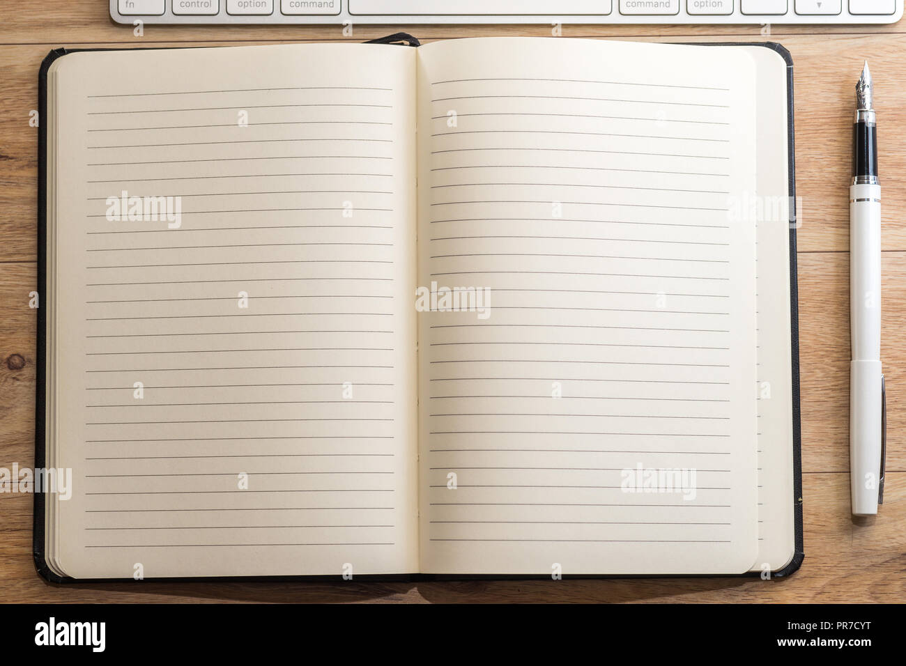 Office table with notepad, keyboard and fountain pen. View from above ...