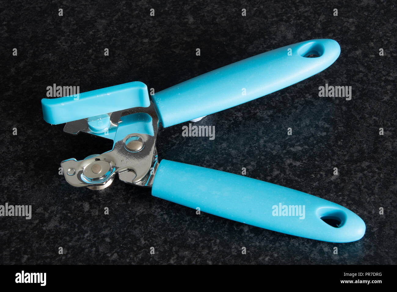 Blue coloured can opener on a dark background Stock Photo - Alamy